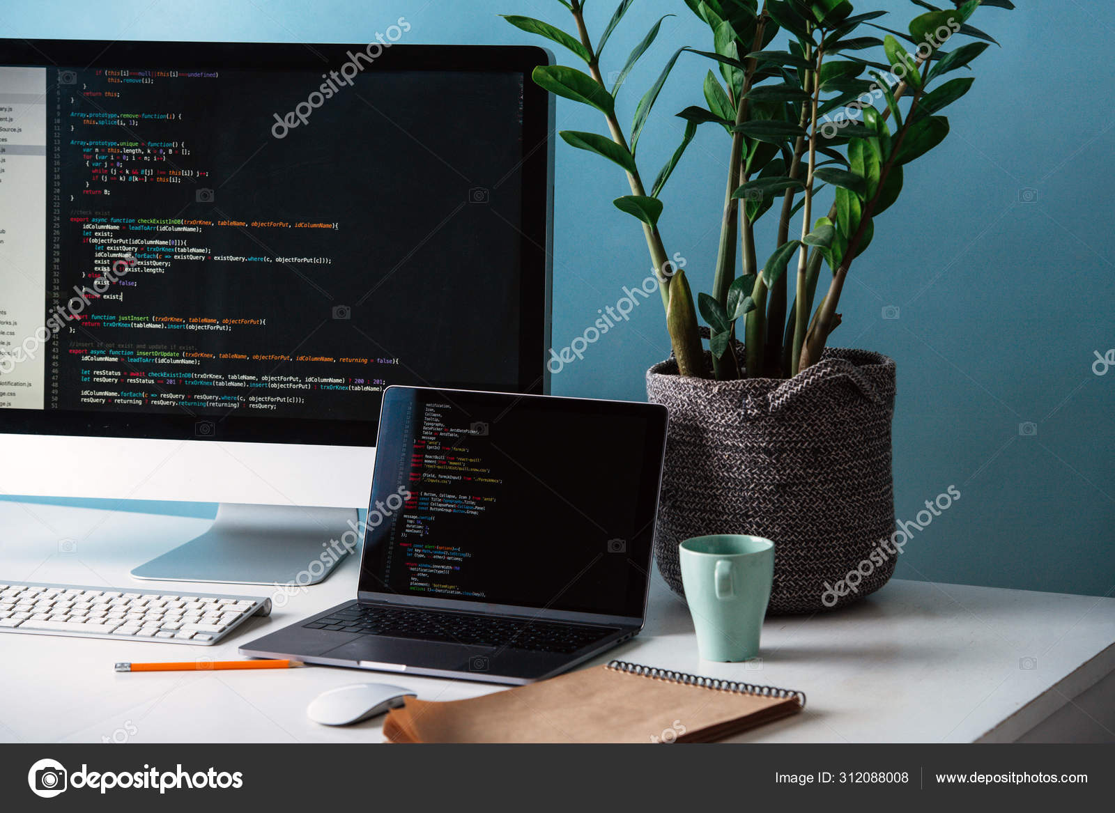 Two black screens, laptop and monitor, filled with program code lines ...