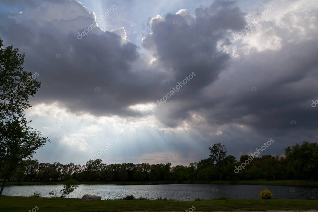 Fuerte rayos de luz brillan a través de nubes de tormenta ondulantes ...