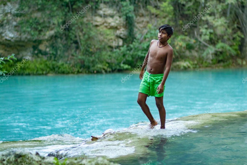 Chico latino divirtiéndose tomando un baño a mediados de octubre en un ...