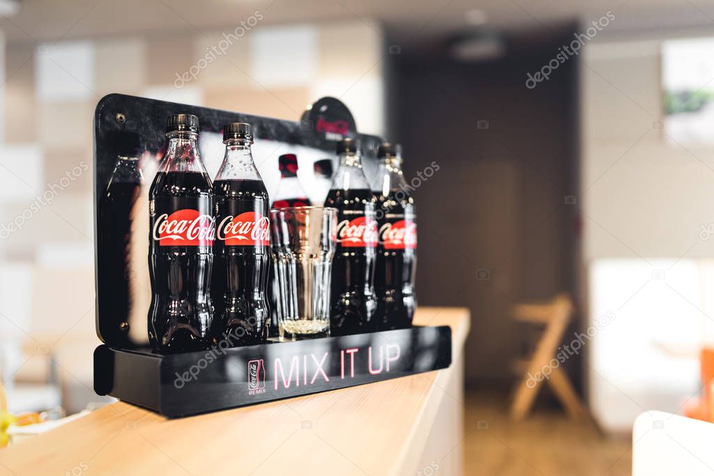 Botellas clásicas de Coca-Cola de pie en el bar, colocadas en el stand ...