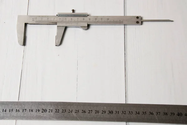 Two metal construction rulers on light wooden background with copy ...