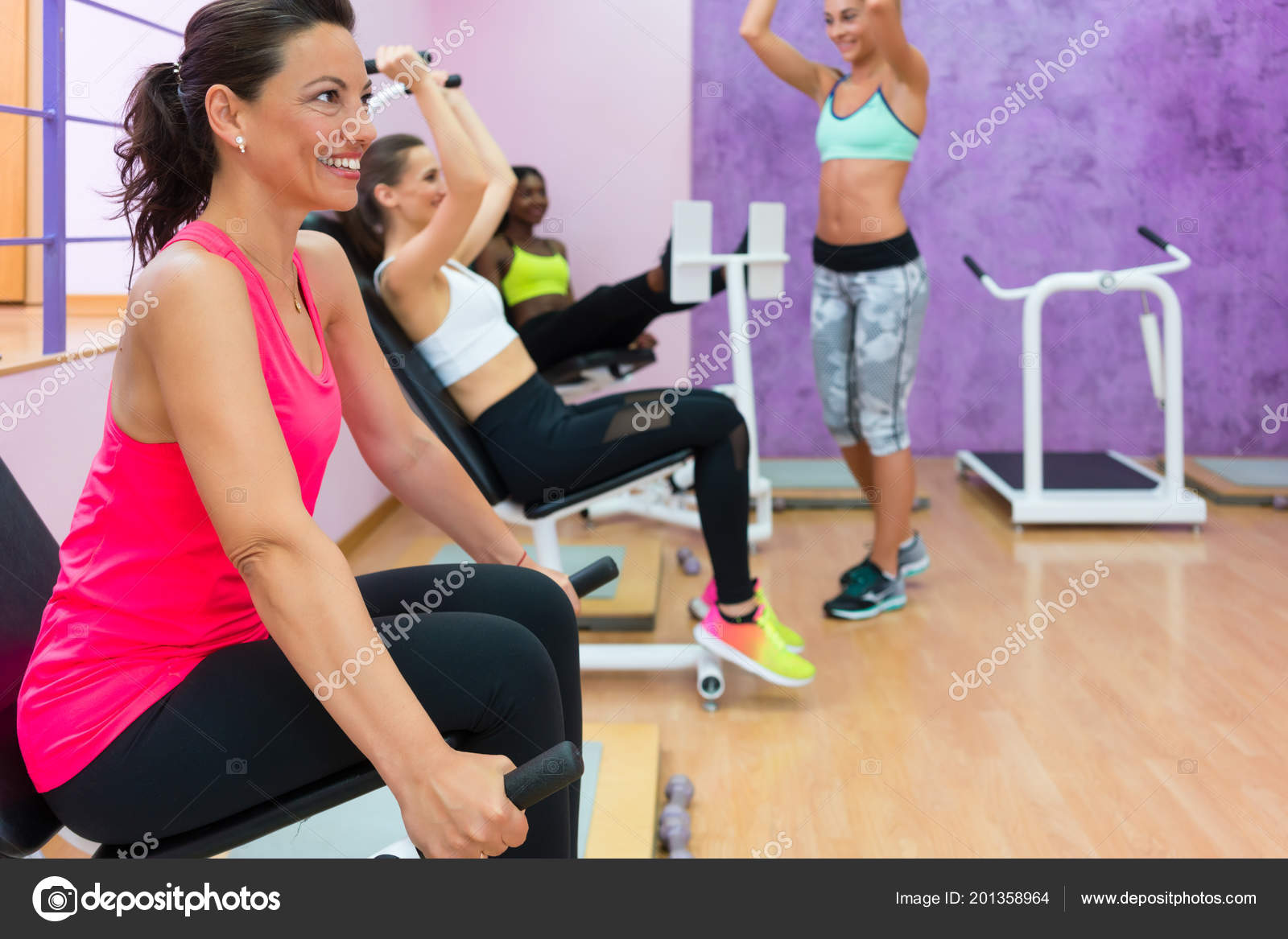Woman in gym using modern equipment for toned arms Stock Photo by ...