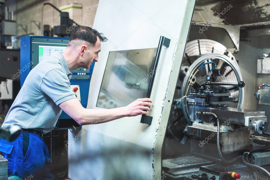 Trabajador que opera un torno CNC en fábrica 2022