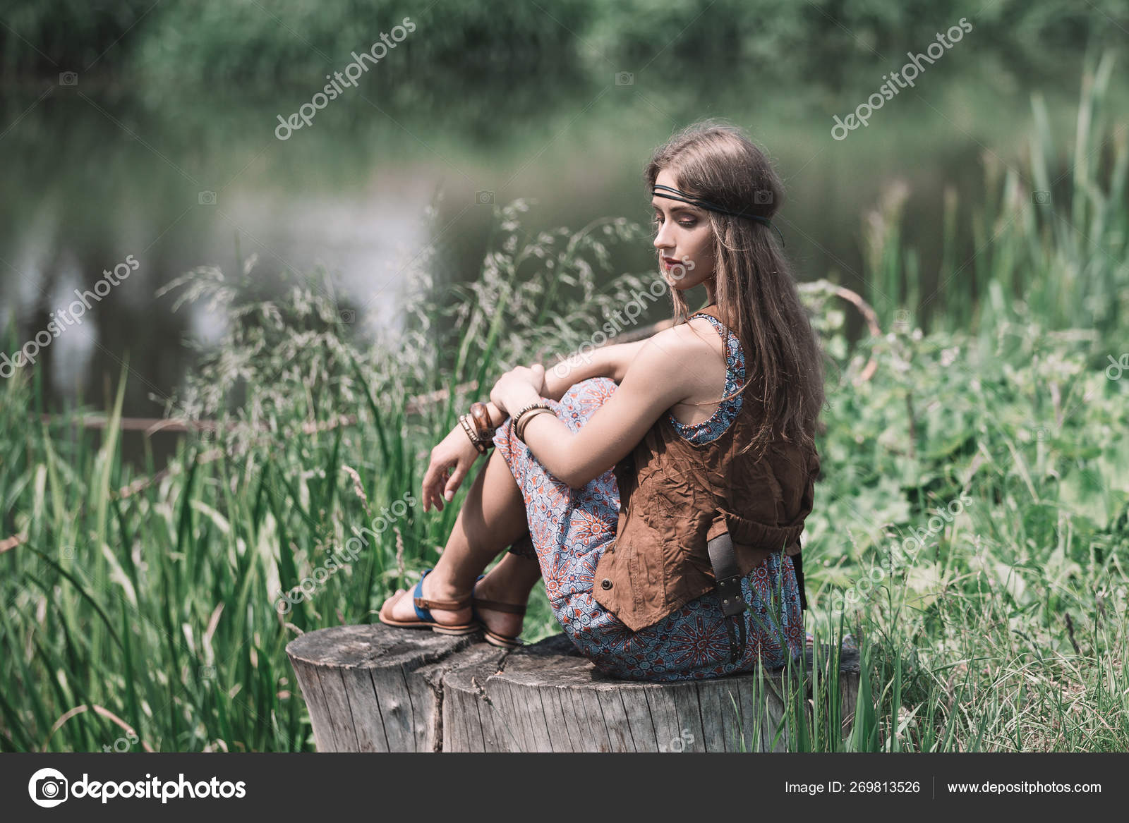 Beautiful hippie girl sitting on a stump near the pond. Stock Photo by ©albertyurolaits 269813526