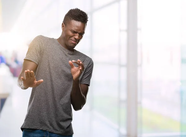 Young african american man wearing grey t-shirt disgusted expression ...
