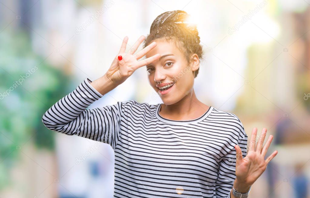 Joven trenzado pelo afroamericano chica usando su ter sobre fondo aislado mostrando y se alando ...