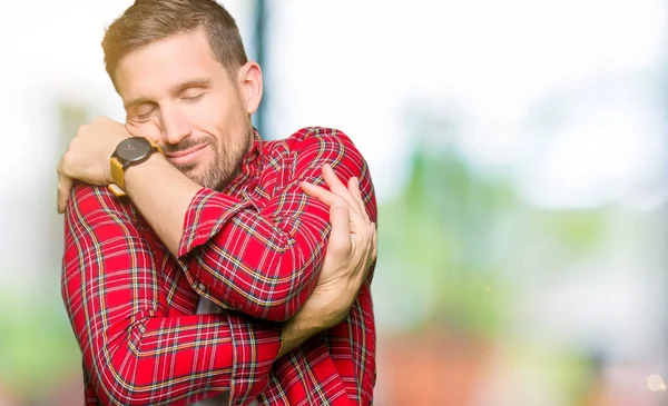 Handsome man wearing casual shirt Hugging oneself happy and positive ...