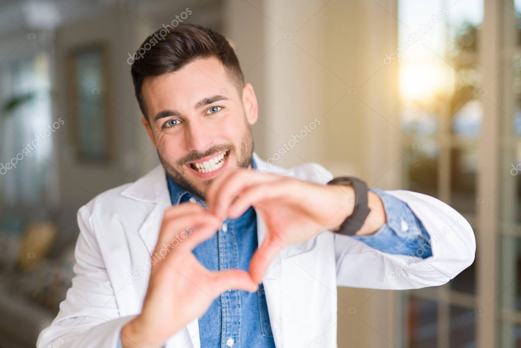 Joven m dico guapo en la cl nica sonriendo en el amor mostrando el s mbolo del coraz n y la ...