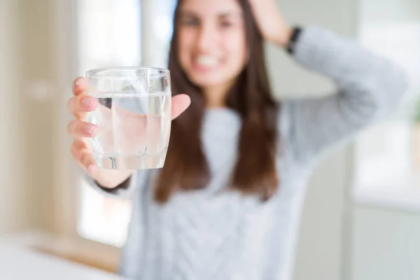 Beautiful young woman drinking a fresh glass of water stressed with ...