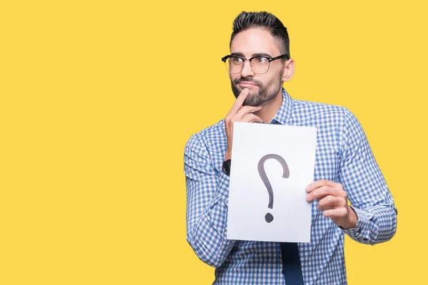 Handsome young business man holding paper with question mark over ...