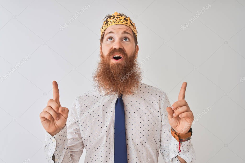 Joven empresario irlandés pelirrojo vistiendo corona rey sobre fondo ...