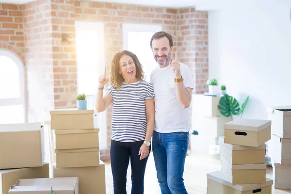Middle age senior couple moving to a new home with boxes around ...