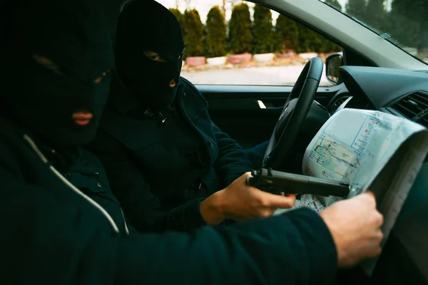 Bank robbers with their masks on pointing at the map prepared for ...