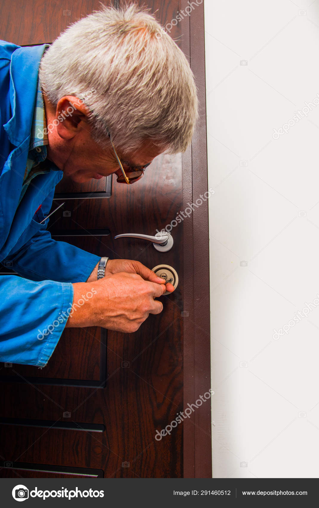 Workman fixing the door lock Stock Photo by ©gorgev 291460512