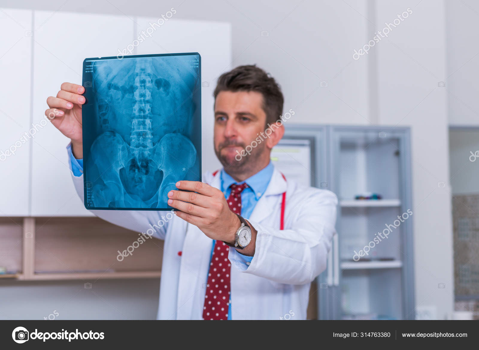 Male Doctor in his mid 40's reading an x-ray image ( radiography ...