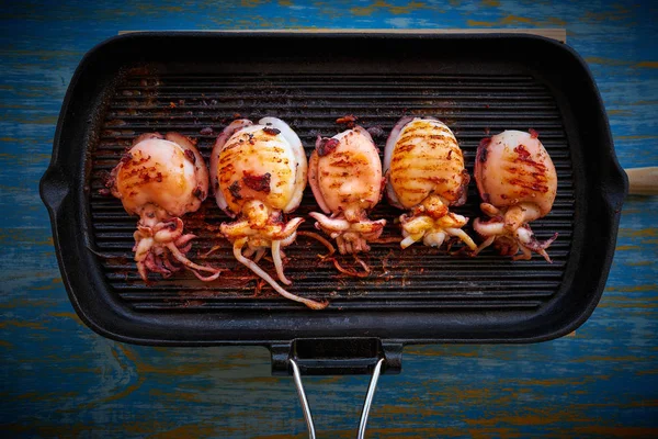 Grilled cuttlefish squid in cast iron grill on wood - Stock Image ...