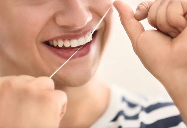 Young man flossing teeth, closeup - Stock Image - Everypixel