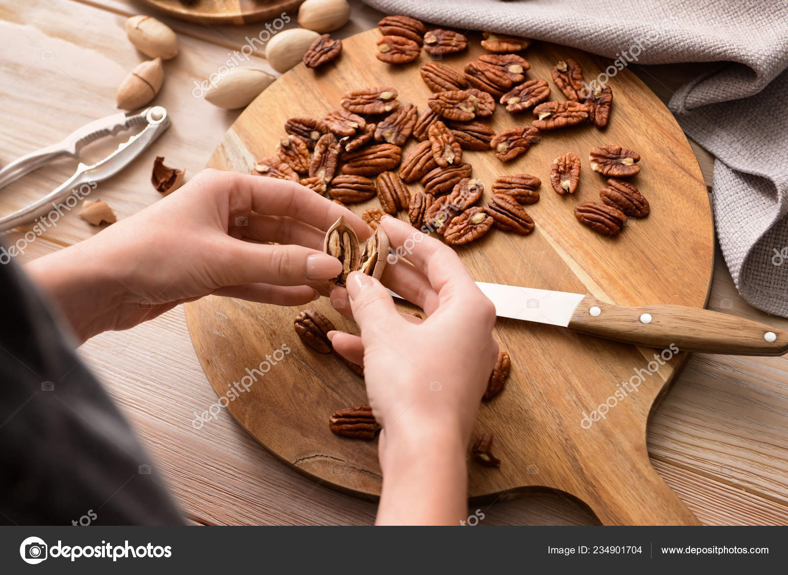 Woman Cracking Pecan Nuts Table Closeup Stock Photo by ©serezniy 234901704