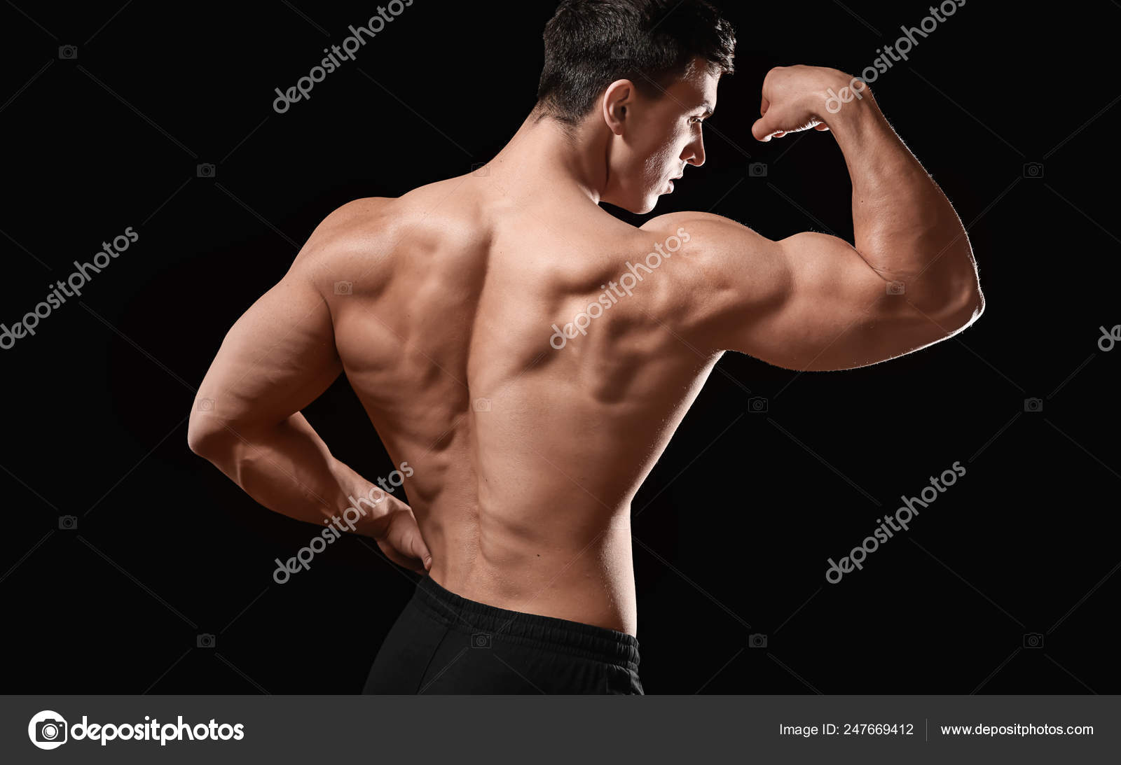Muscular bodybuilder on dark background, back view Stock Photo by ...