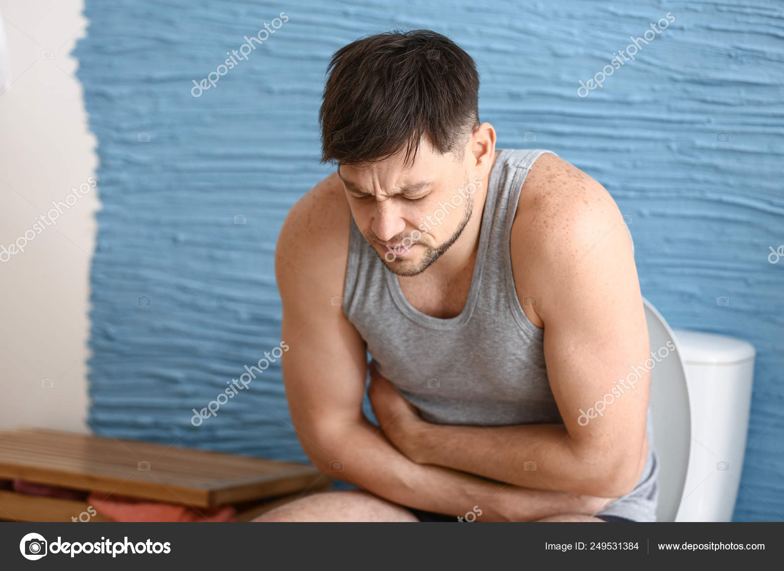 Man suffering from diarrhea while sitting on toilet bowl at home ⬇ ...