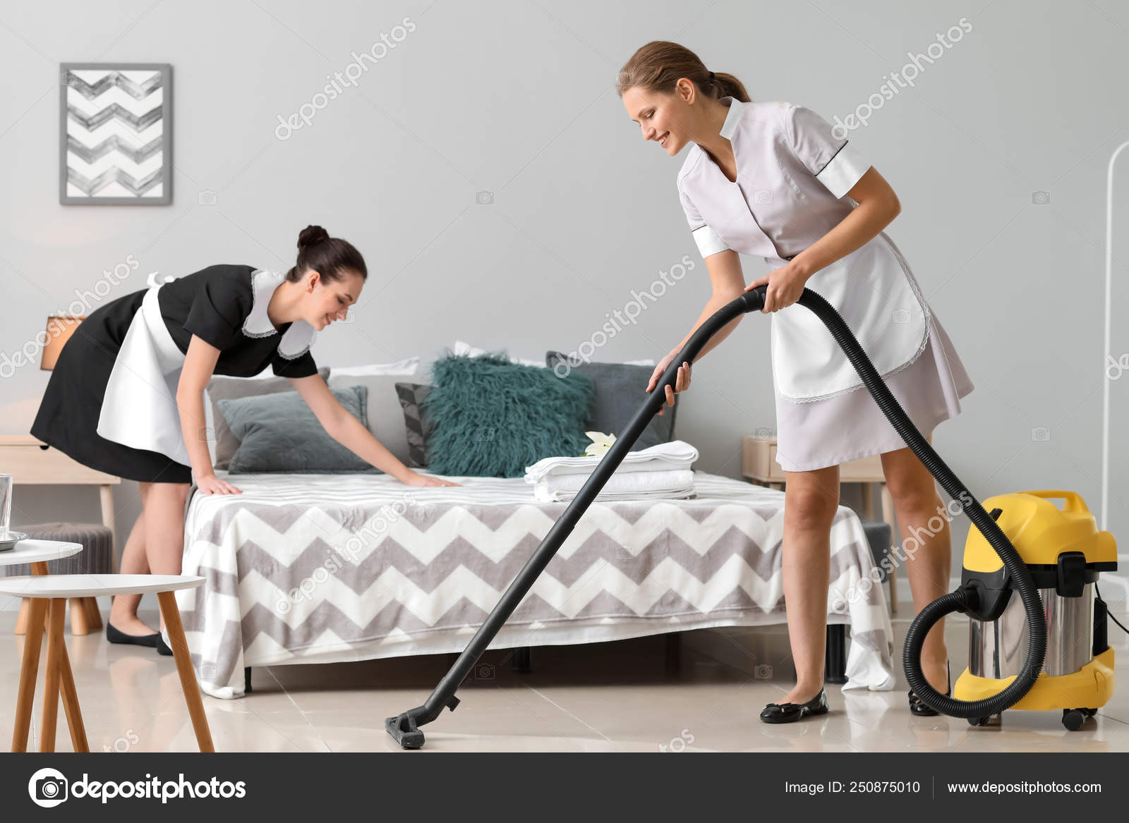 Beautiful female housekeepers working in room Stock Photo by ©serezniy ...