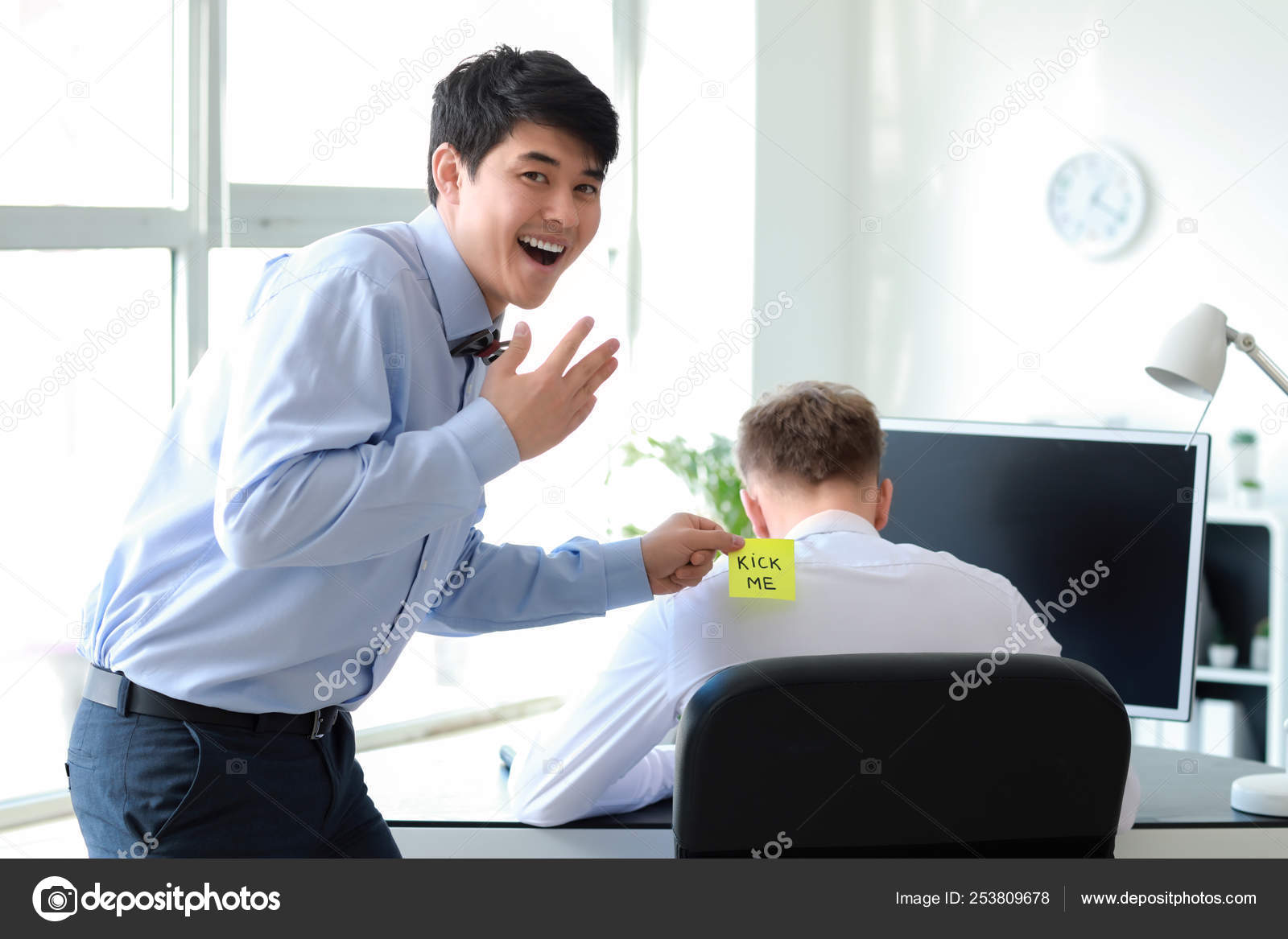 Asian man playing a prank on his colleague in office. April Fools' Day ...