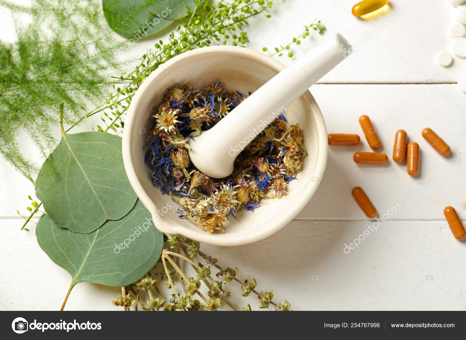 Mortero con flores secas, hierbas y píldoras a base de plantas en la ...