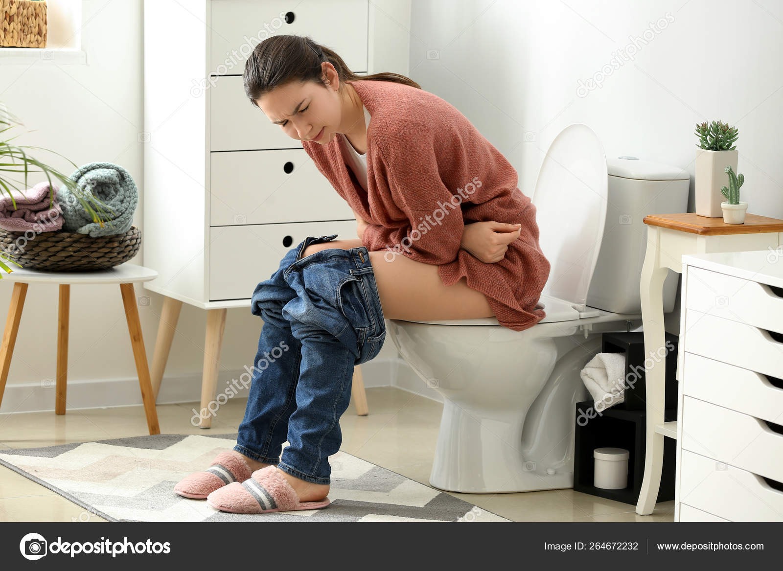 Young woman suffering from diarrhea on toilet bowl at home — Stock Photo © serezniy #264672232