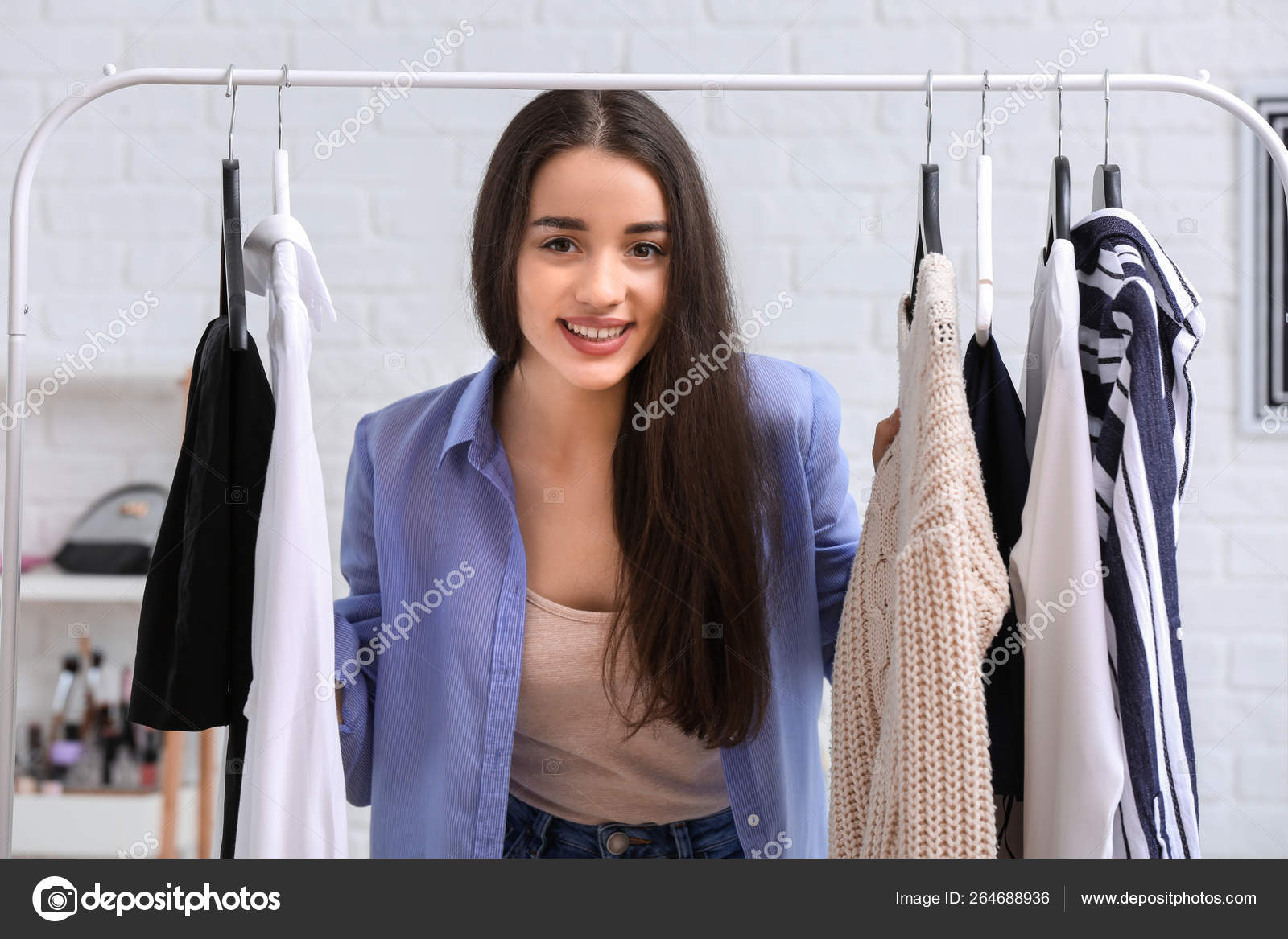 Young woman choosing clothes in dressing room Stock Photo by ©serezniy ...