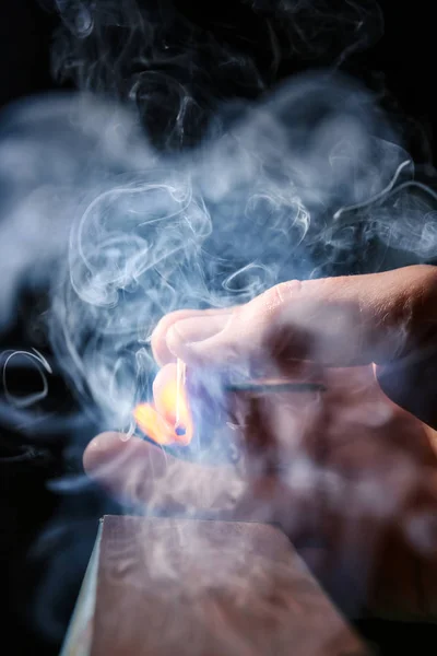 Man striking match on dark background - Stock Image - Everypixel