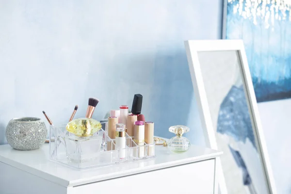 Different makeup products and accessories on dressing table in room ...