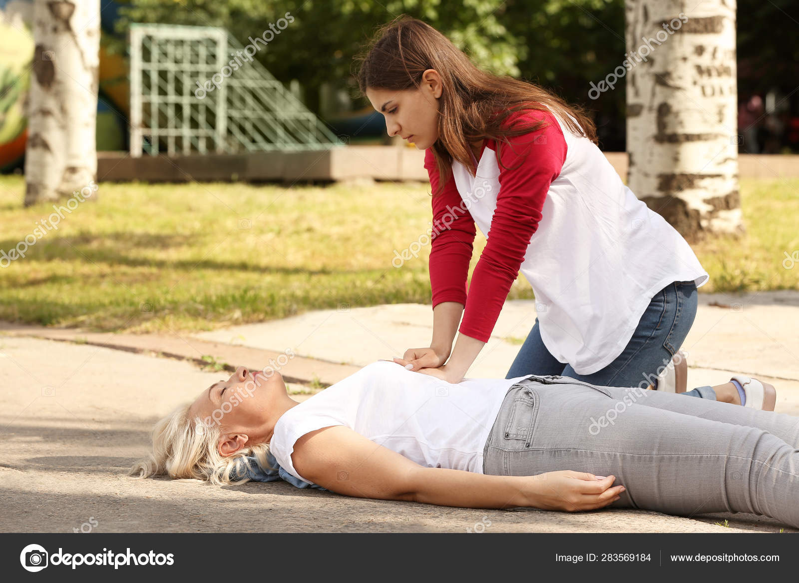 Female passer-by doing CPR on unconscious mature woman outdoors — Stock ...