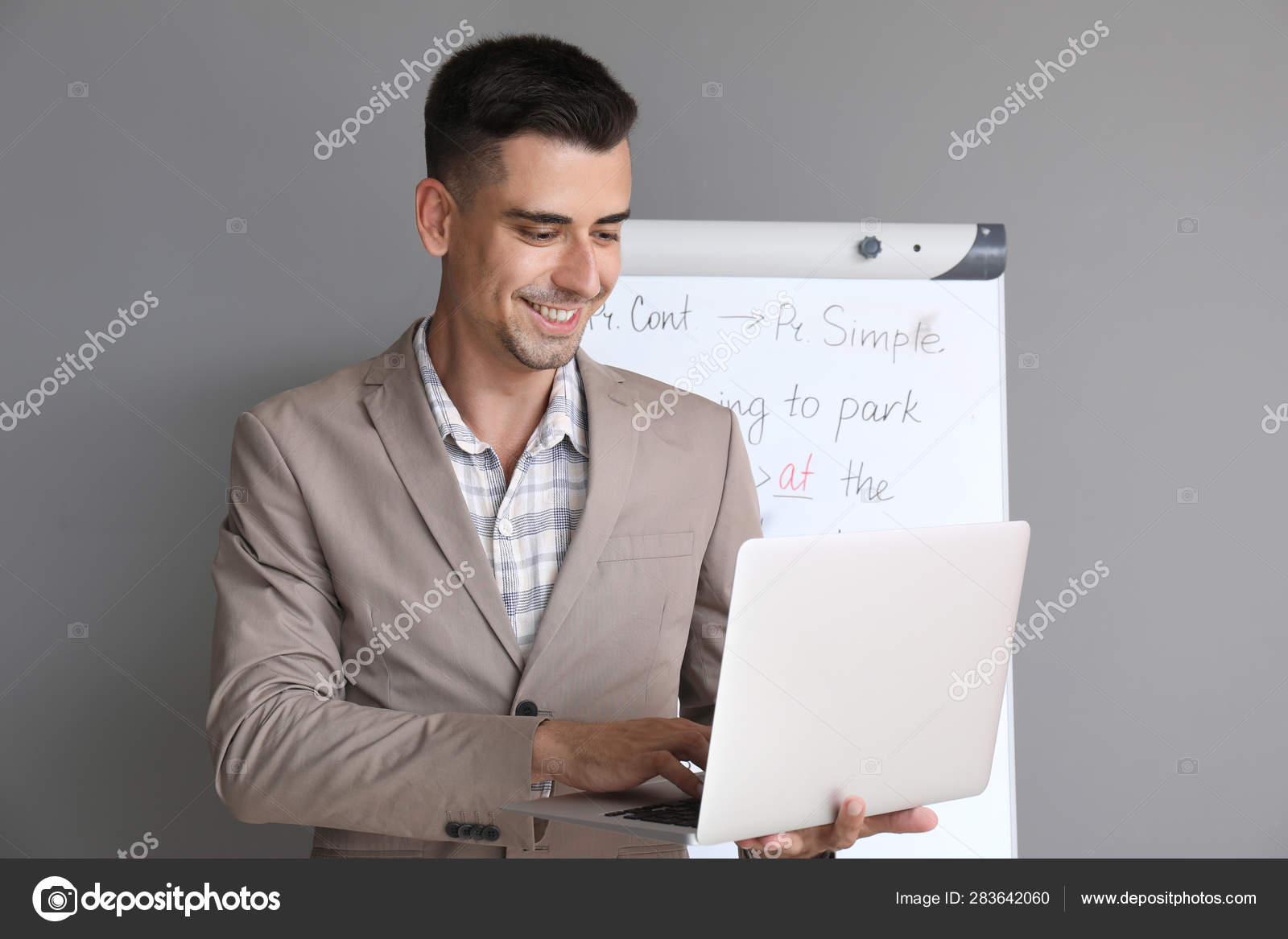Handsome male teacher with laptop in classroom Stock Photo by ©serezniy ...