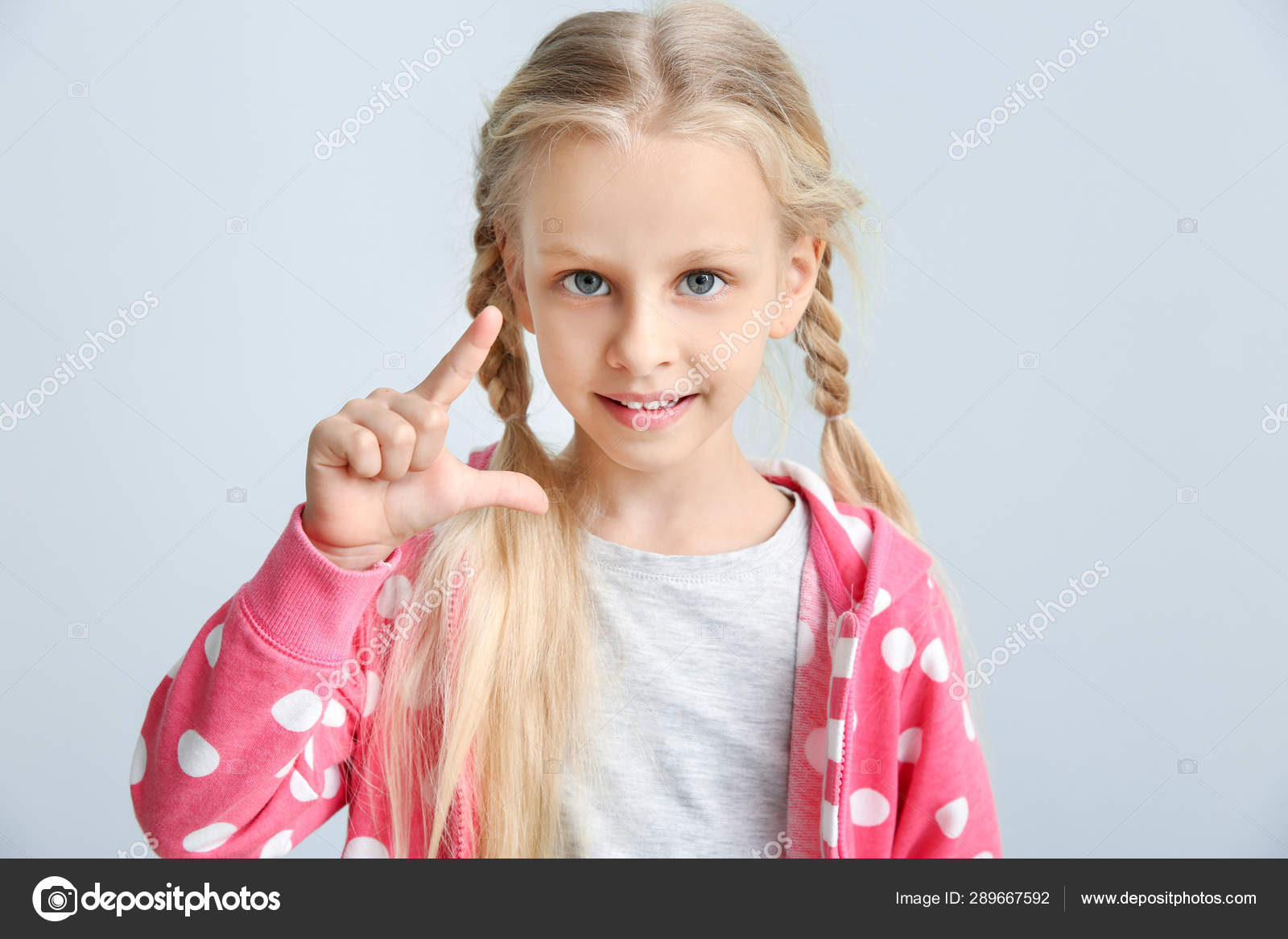 Little deaf mute girl using sign language on light background Stock ...