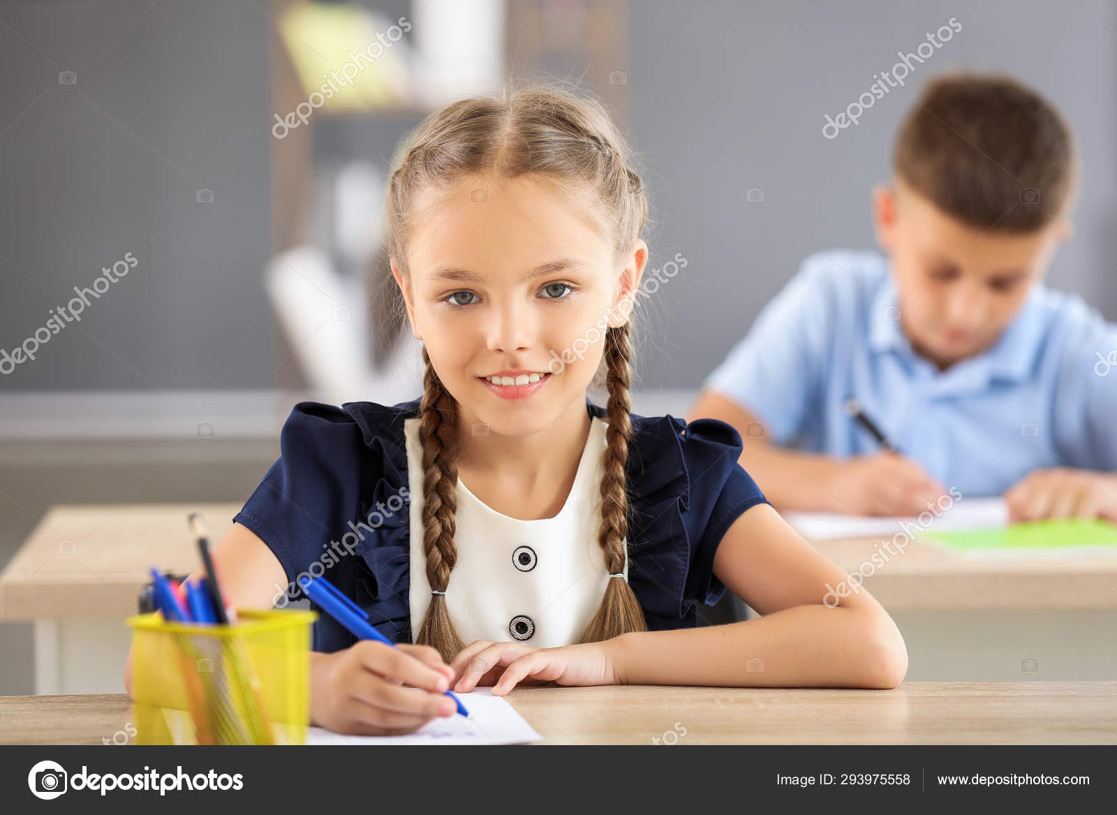 Pupil passing school test in classroom Stock Photo by ©serezniy 293975558