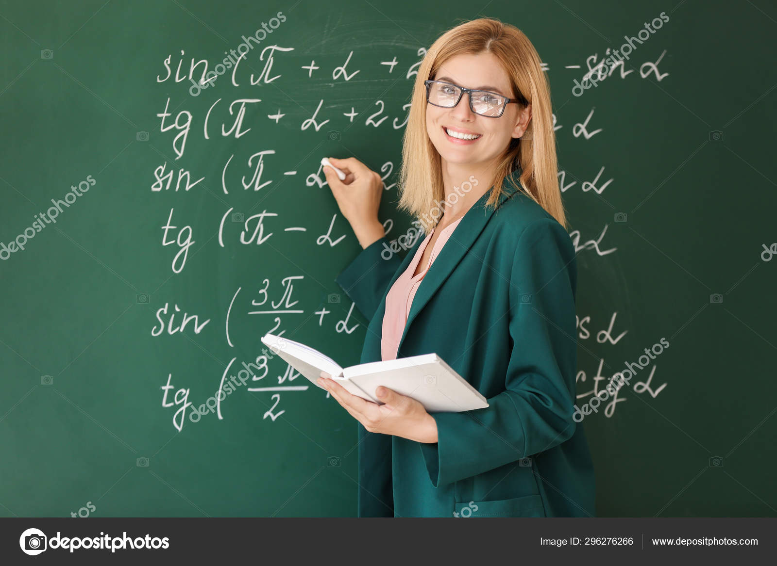 Beautiful math teacher with book near blackboard in classroom — Stock ...