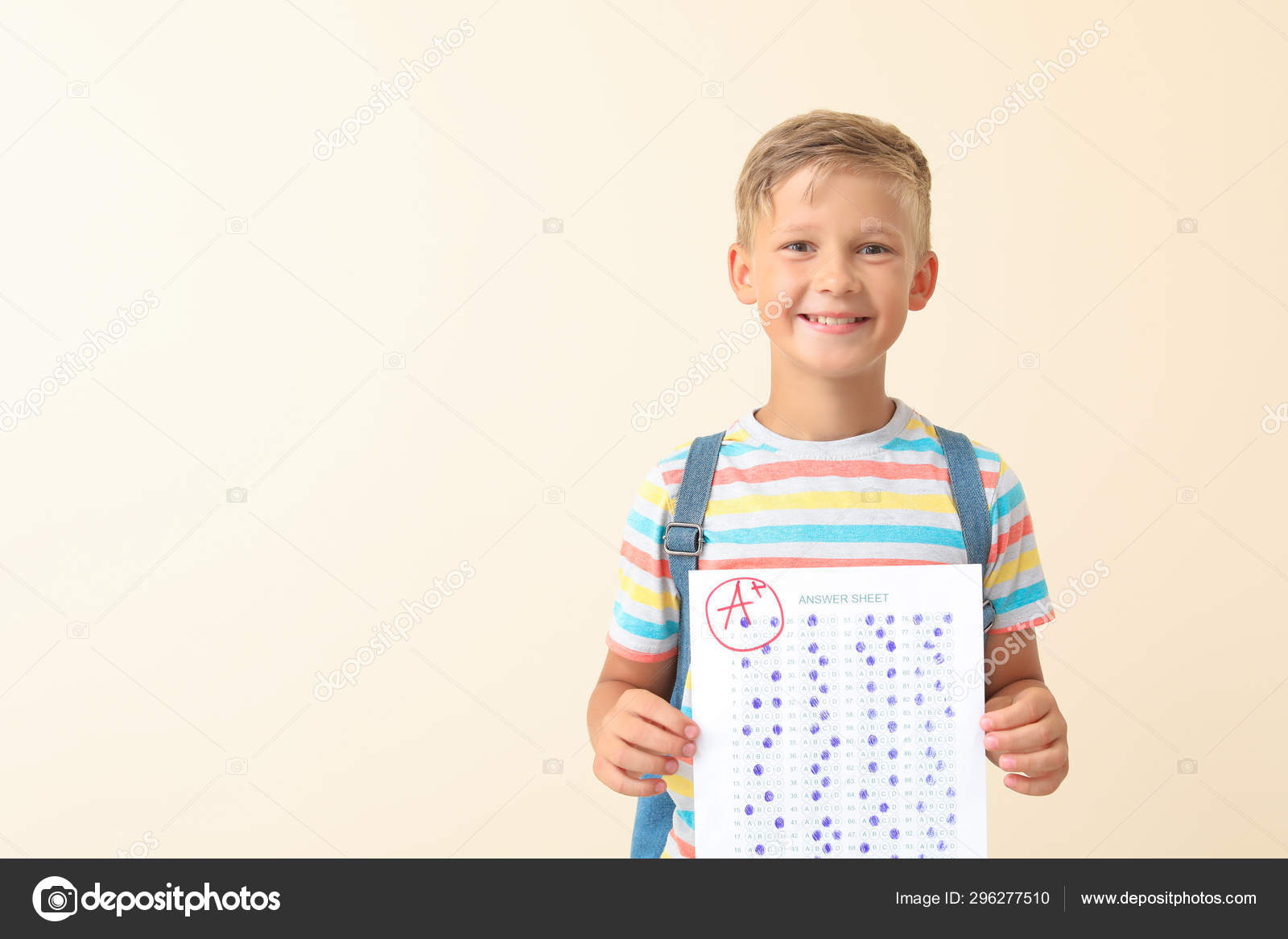 Happy boy with answer sheet for school test on light background Stock ...