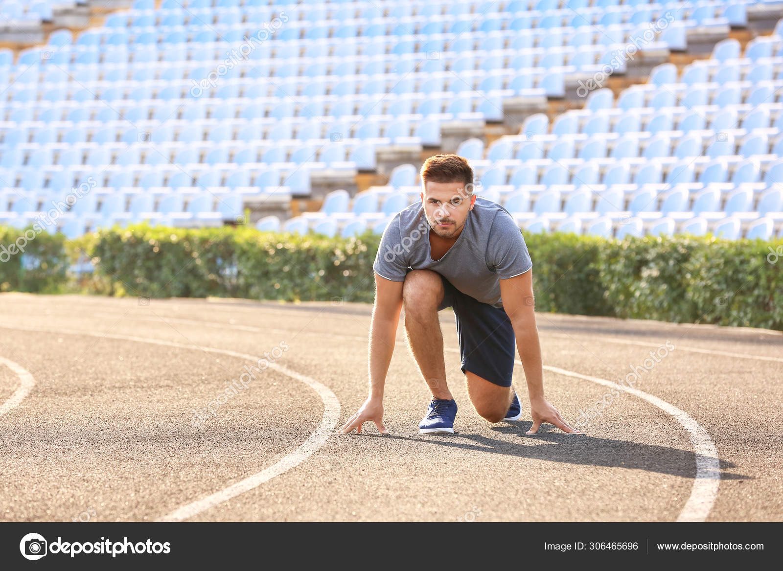 Sporty man in crouch start position at the stadium Stock Photo by ...