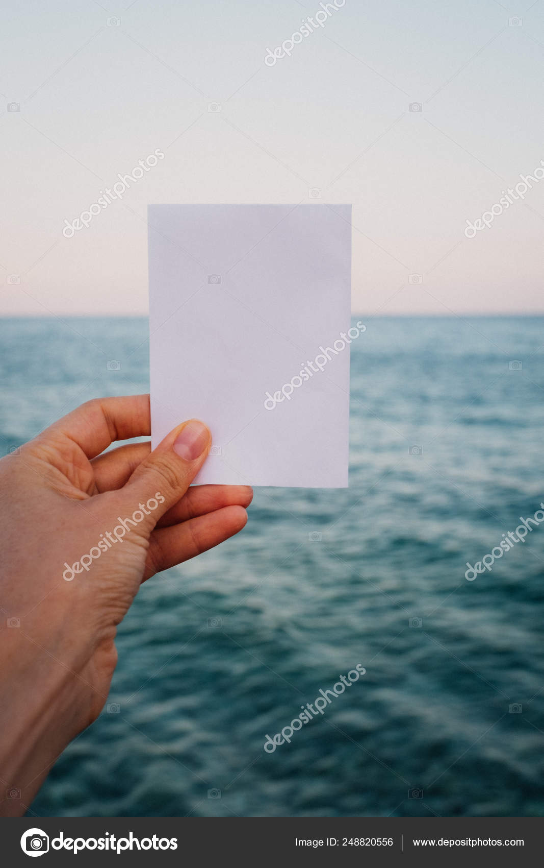Empty paper note in hand at amazing landscape background. Travel and ...