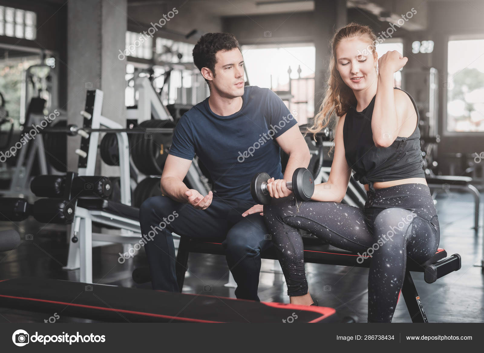 Couple discussing about workinhout on bench in gym Stock Photo by ...