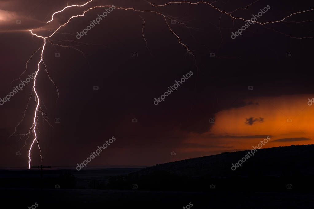 Un gran rayo cae al atardecer en una llanura abierta enmarcada contra ...