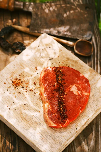 chipotle flakes chilli spice with bbq raw beef steak on wooden board ...