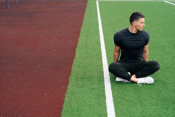 Stretching the pectoral muscles is a young athlete. The male coach does ...