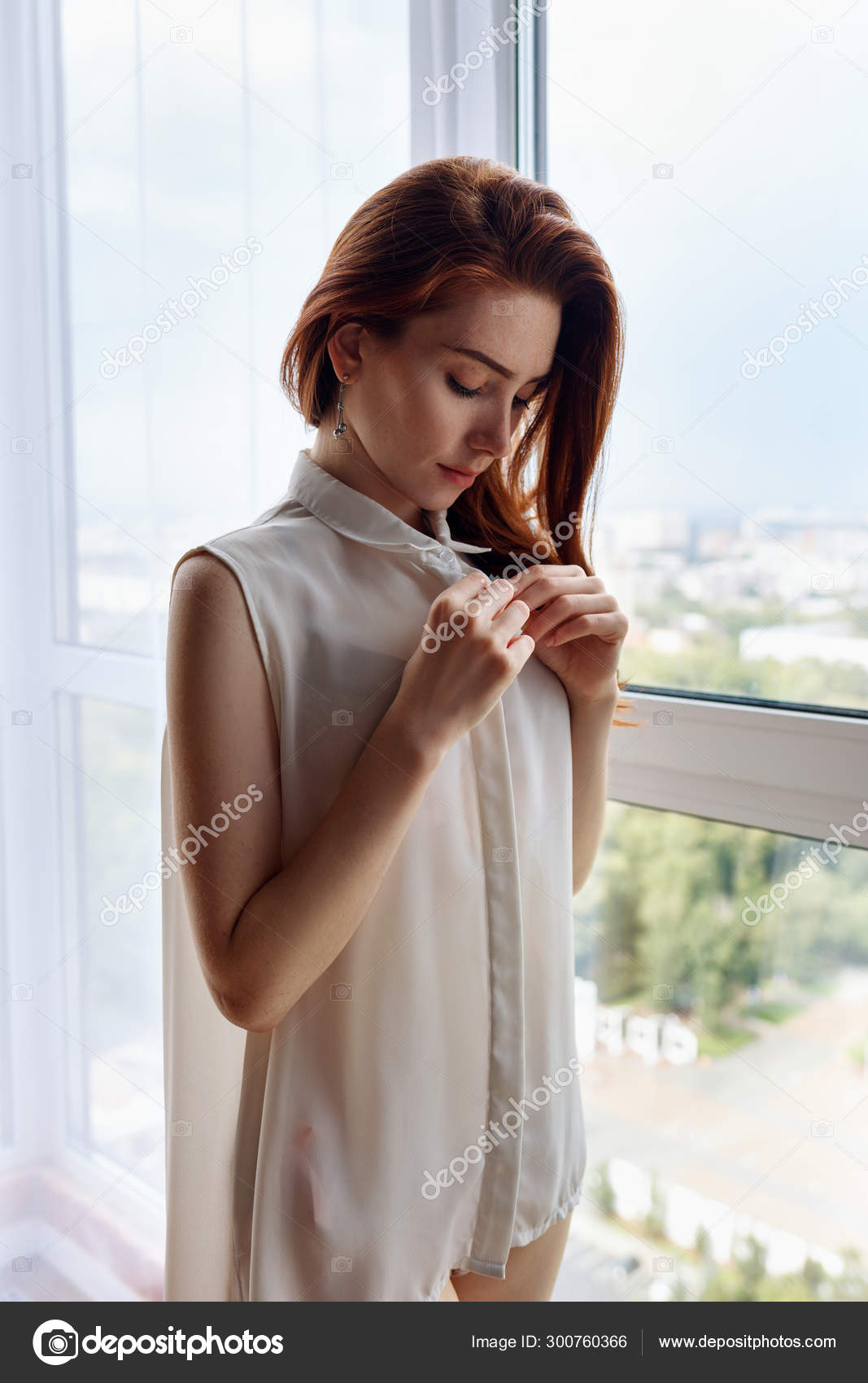 Redhead woman unbuttoning white blouse at home. Stock Photo by ©kotin ...