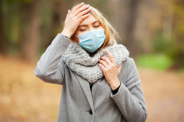 Cold and flu. Woman with a medical face mask at outdoor in autumn ...