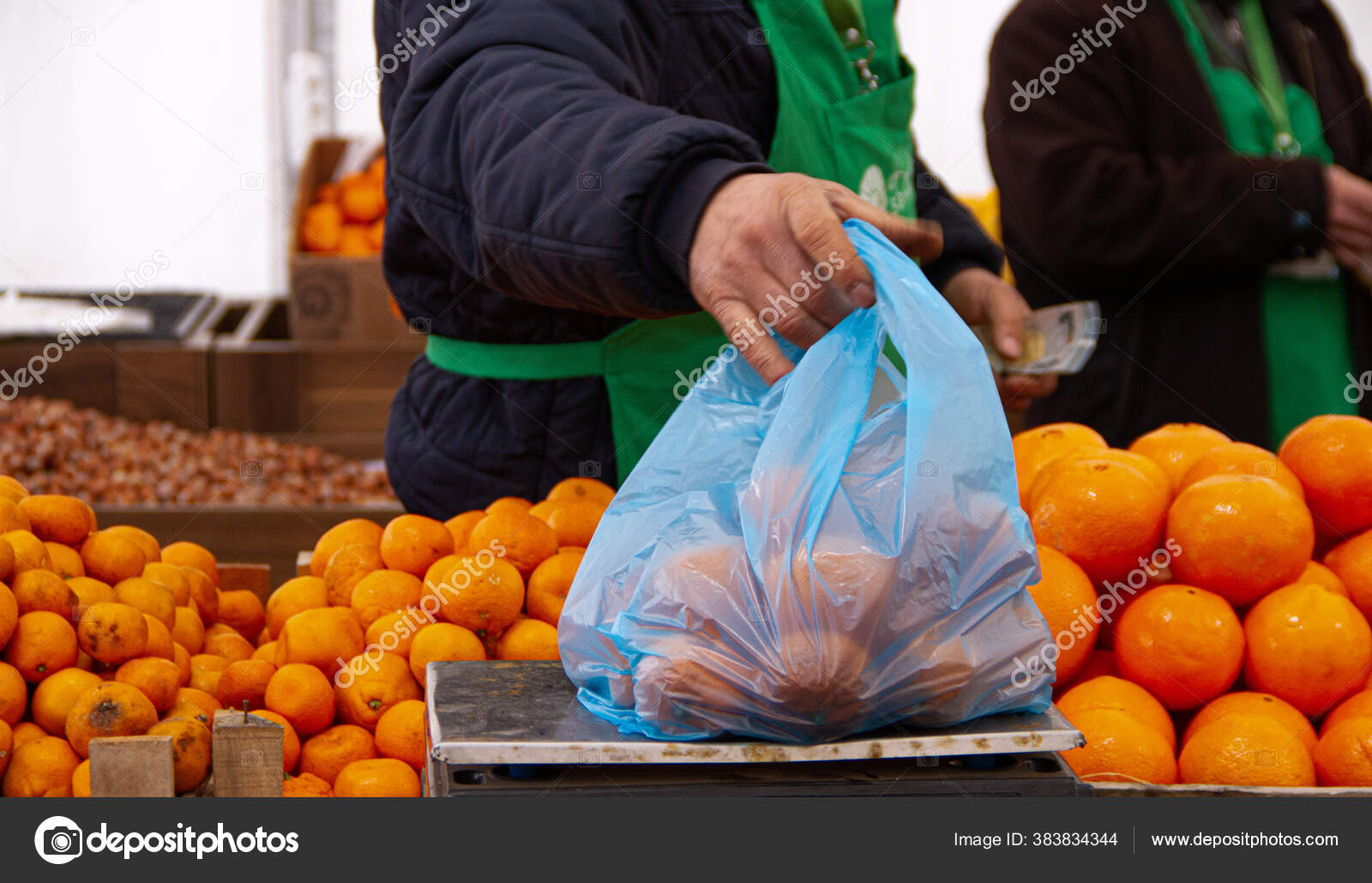 Grocery staff measuring the weight of oranges Stock Photo by ...