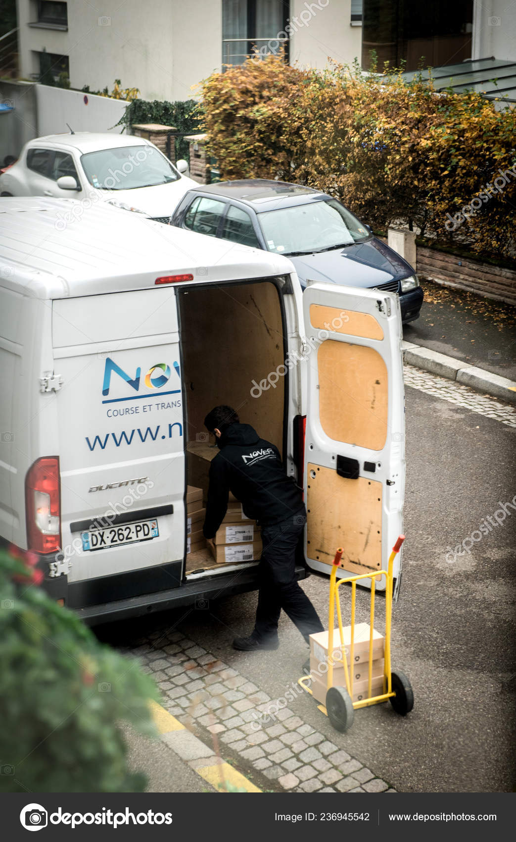 Man unloading on carriage trolley from delivery truck – Stock Editorial ...