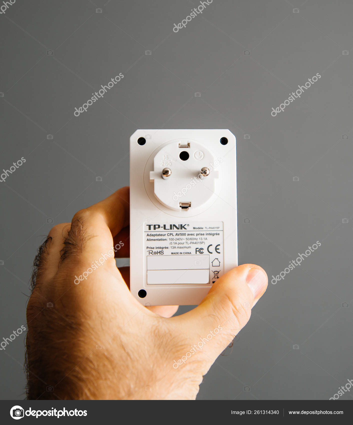 Hombre sosteniendo powerline adaptador Ethernet fondo gris — Foto ...