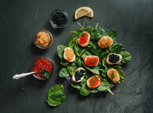 Sandwiches con caviar de salmón rojo, caviar negro de esturión y caviar ...