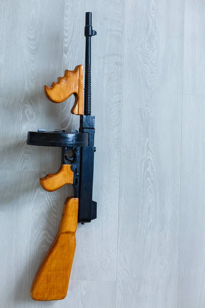 Hanged wooden thompson machine gun and automatic rifle toys at counter ...